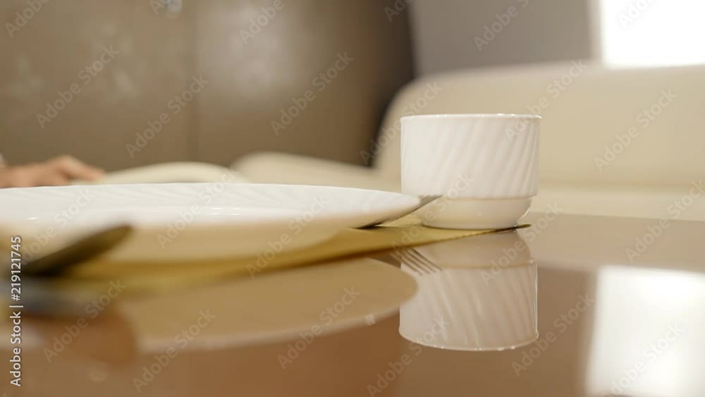 Young stewardess is serving businessman, putting cup on table in ...