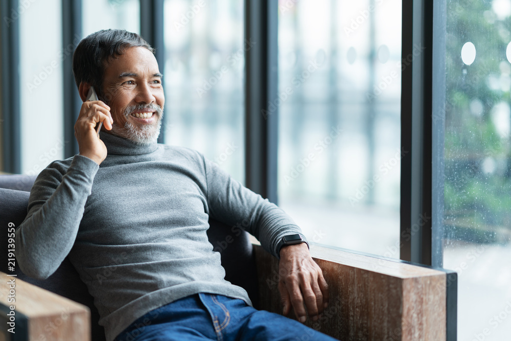 Smiling Happy Mature Asian Man With White Stylish Short Beard Using
