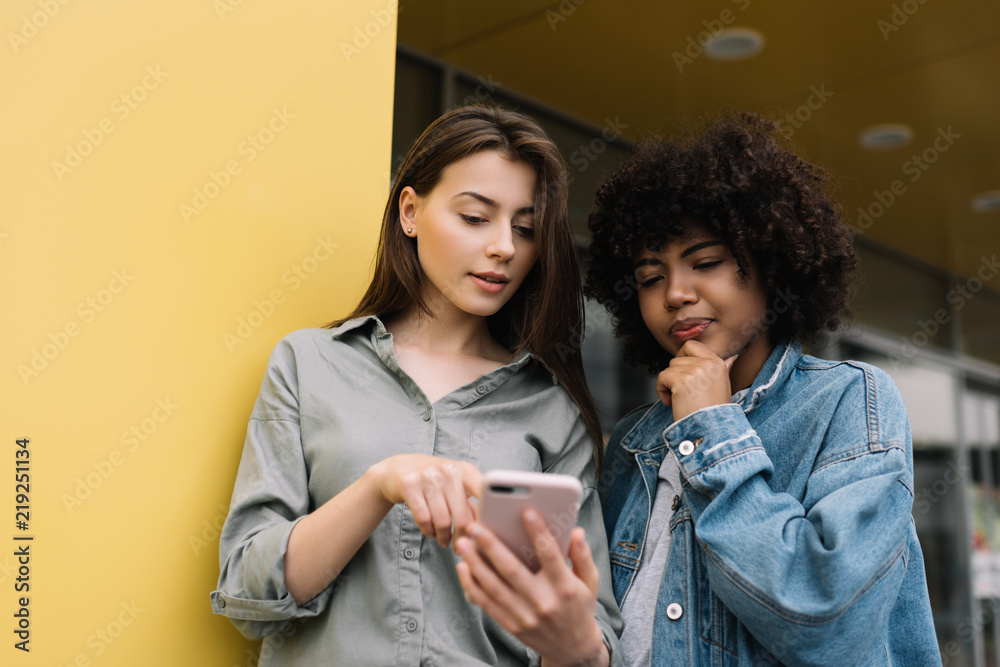 Young multiracial hipsters friends using modern smartphone for shopping ...