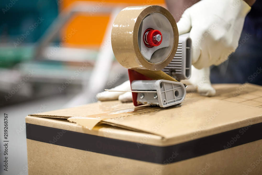 Box being taped shut in packaging plant. Stock Photo | Adobe Stock
