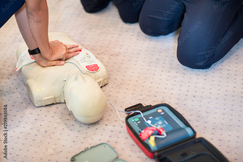 CPR training using and an AED and bag mask valve on an adult training ...