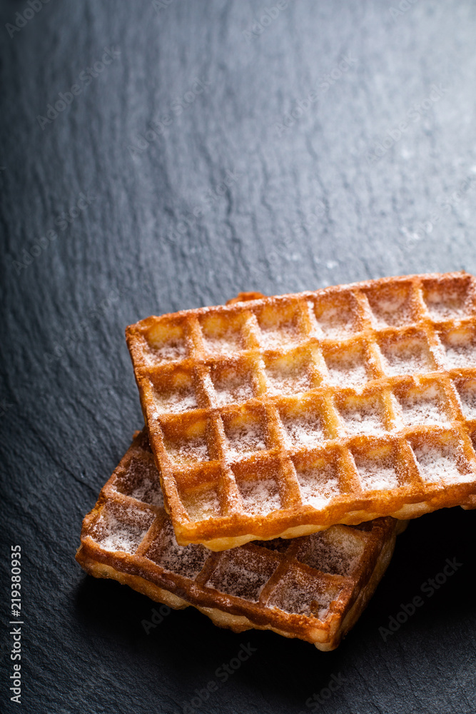 Food concept Classic square Waffles with icing sugat toping on black ...