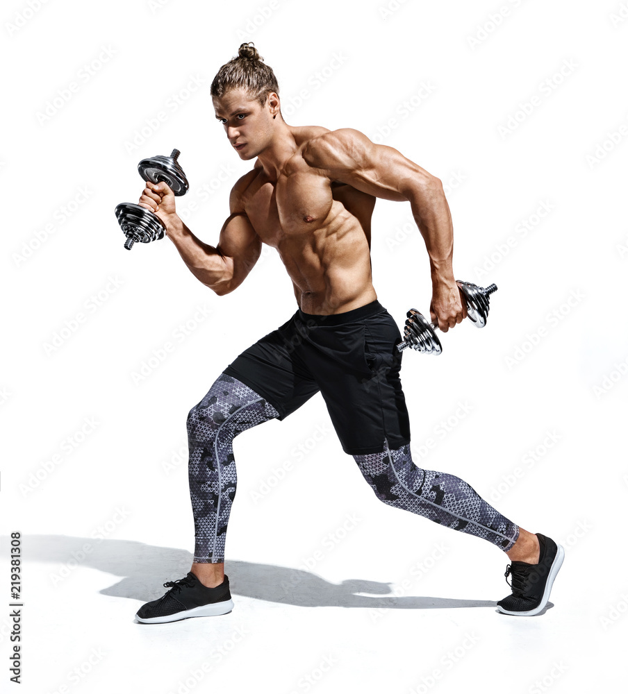 Sporty man training muscles of hands and legs using a dumbbells. Photo ...
