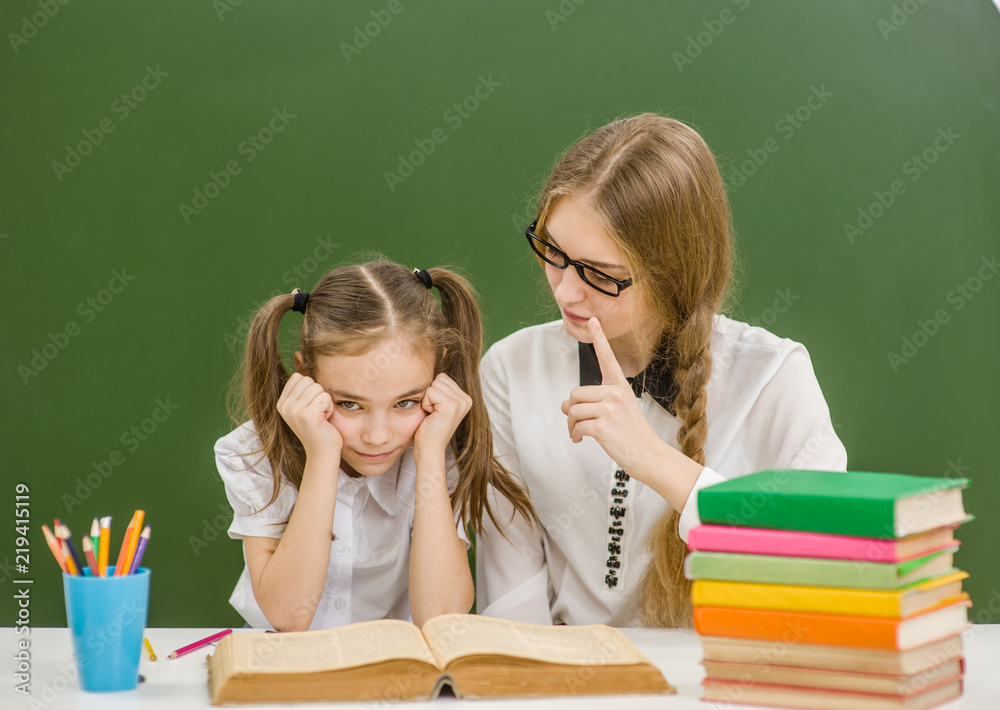 Young teacher scolds the little girl at school Stock Photo | Adobe Stock