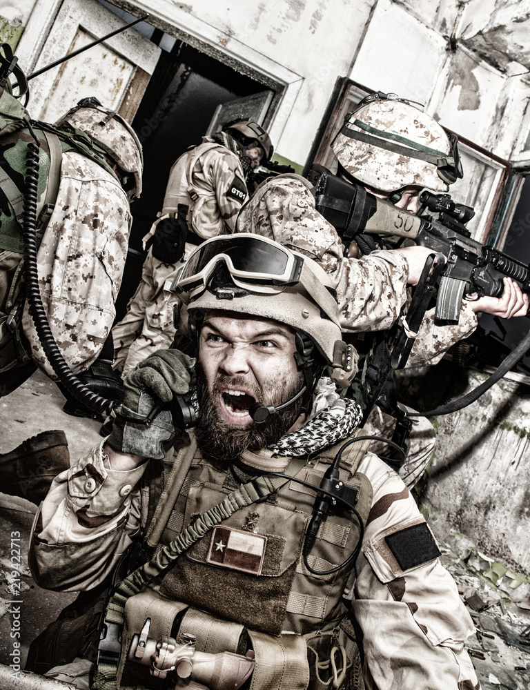 Special forces team leader screaming in tactical radio handset while ...