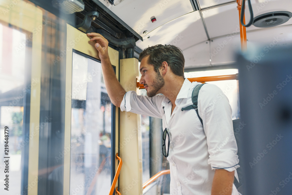 Businessman taking ride to work, standing inside train. Young man ...
