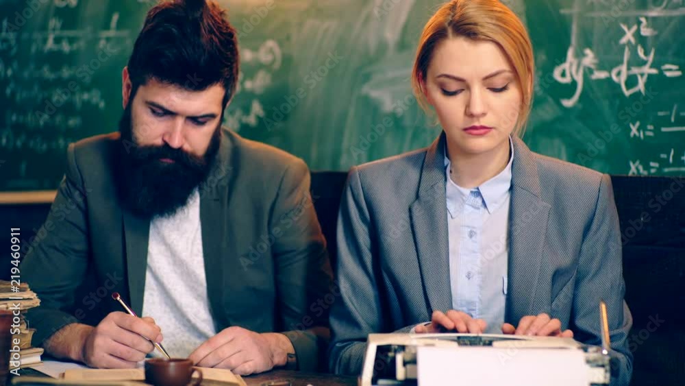 Two teachers are engaged in paper work in the school class. Learning ...