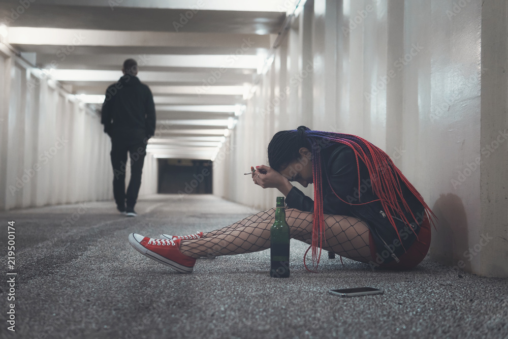 She crying of separation from lover. Girl sits with a bottle of alcohol ...