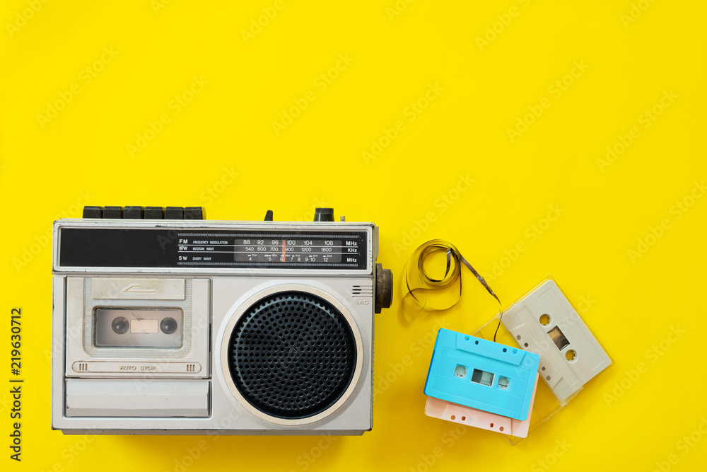vintage radio and cassette player on yellow background, flat lay, top ...