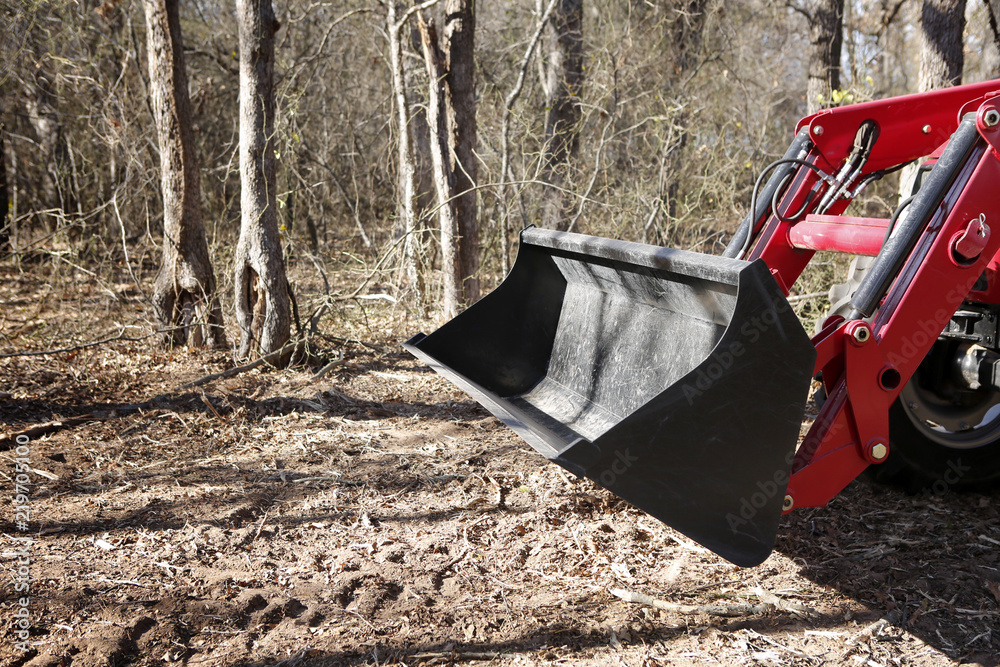 Tractor front end loader in front of woods on construction side. Stock ...