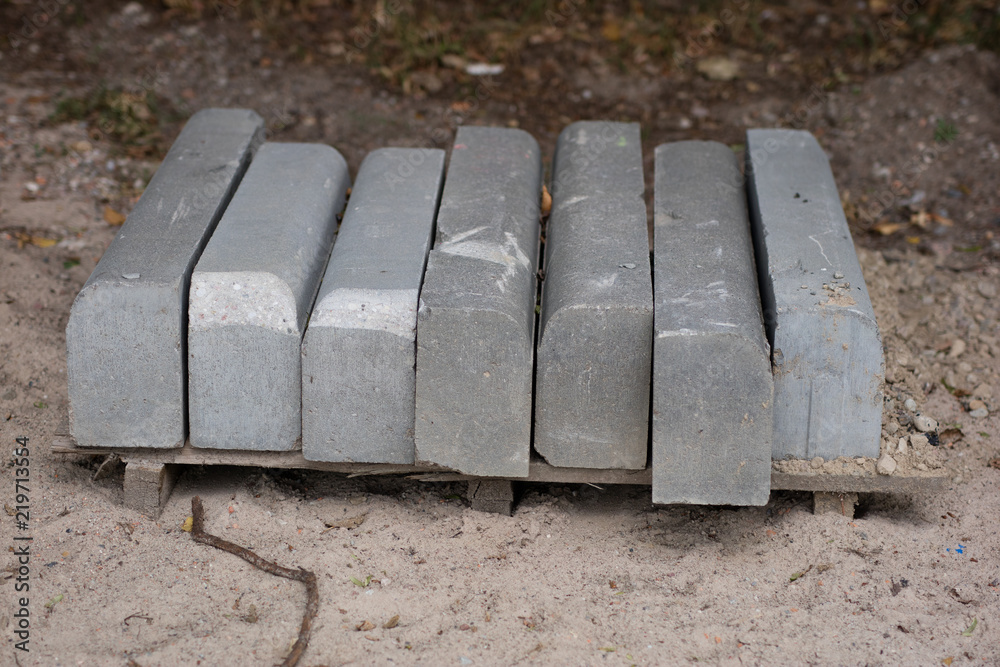 Road construction materials stacked on a pallet. Concrete curb for ...