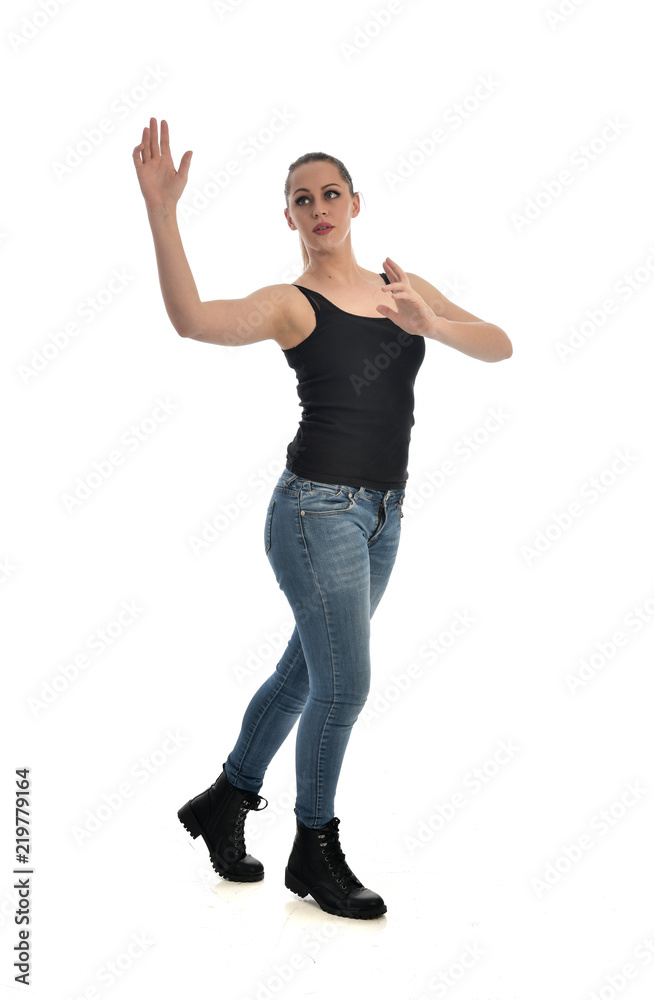 full length portrait of brunette girl wearing black single and jeans ...