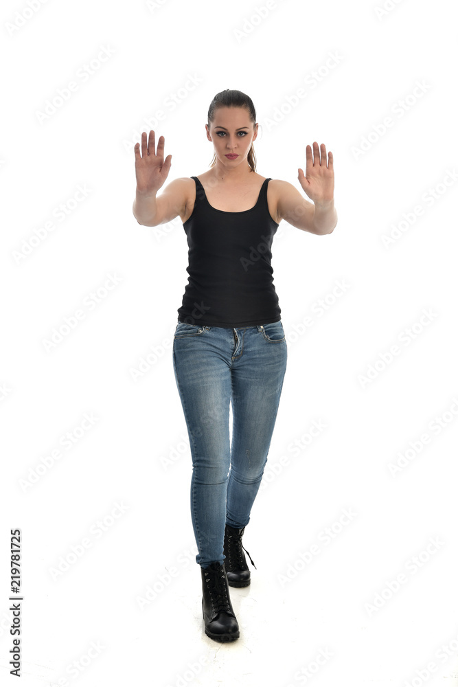 full length portrait of brunette girl wearing black single and jeans ...