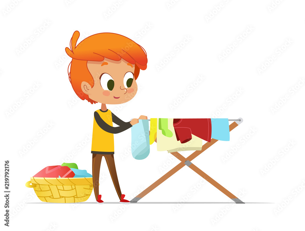 Adorable little redhead boy hanging washed clothes on drying rack ...