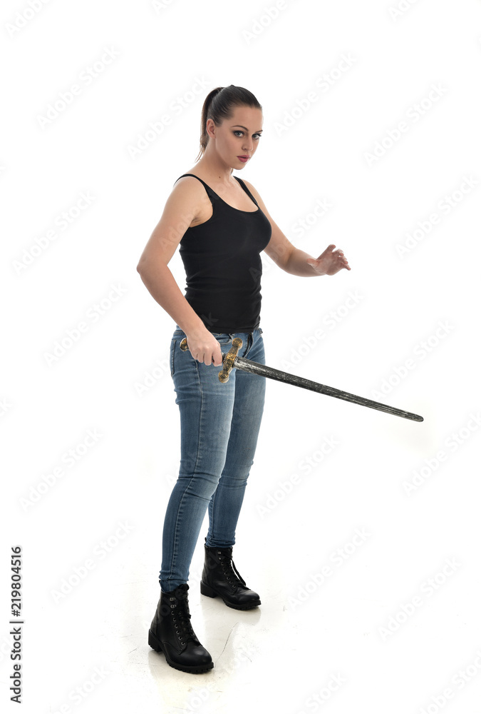 full length portrait of brunette girl wearing black single and jeans ...