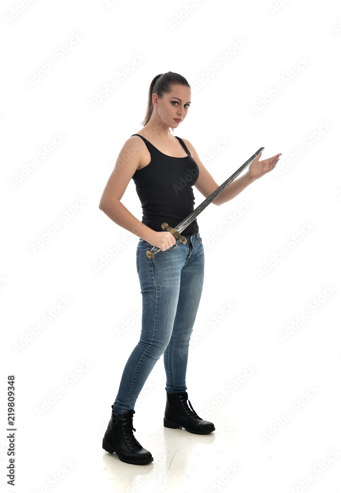 full length portrait of brunette girl wearing black single and jeans ...
