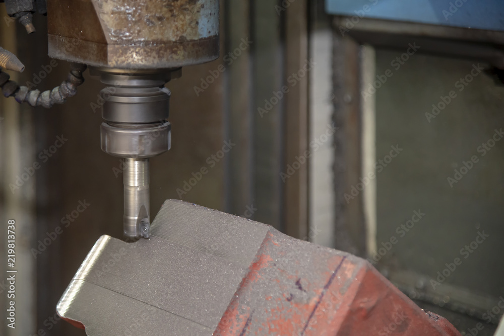 The CNC milling machine cutting the cast iron of press die part in ...