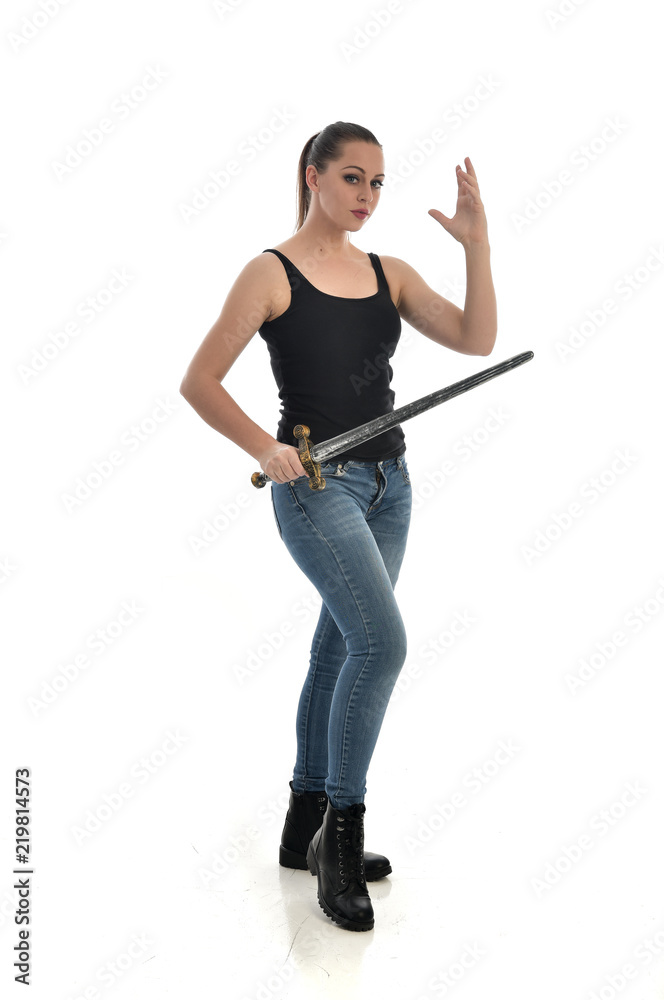 full length portrait of brunette girl wearing black single and jeans ...