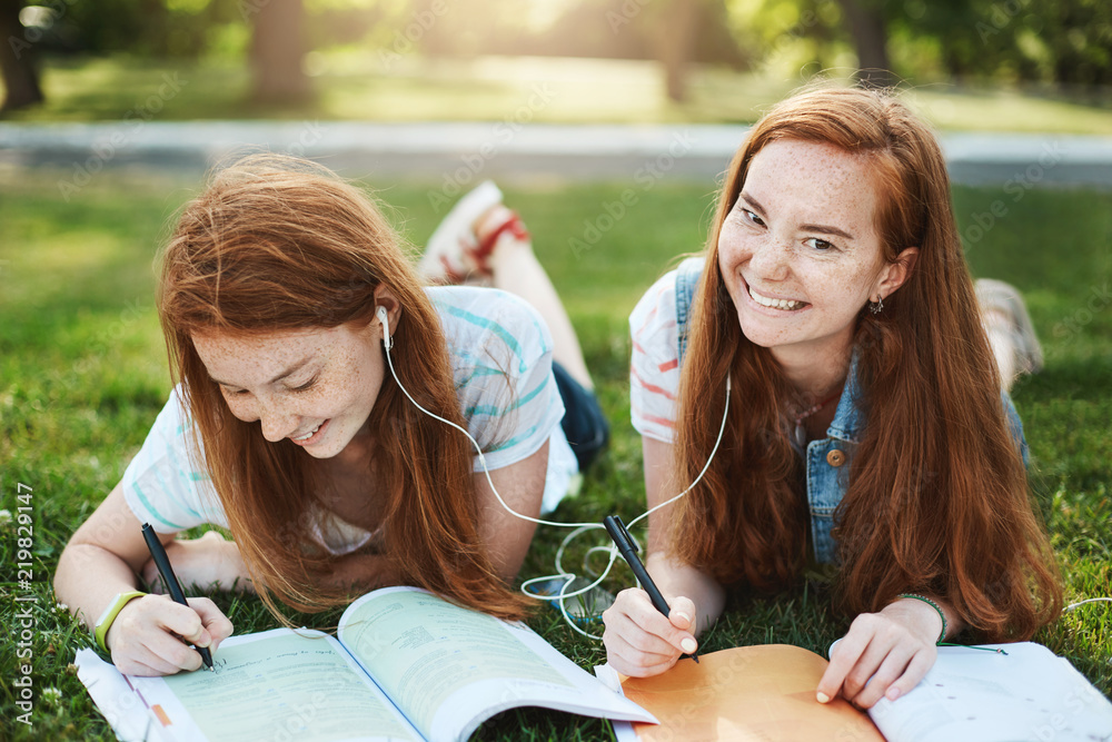 Stop fooling around and do homework. Two relaxed and carefree redhead ...