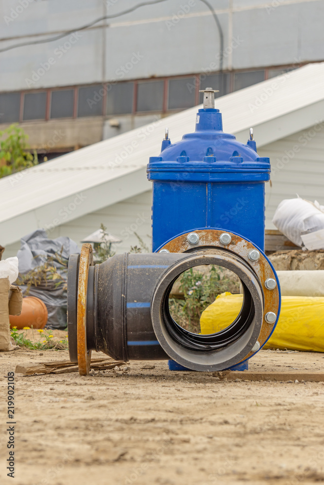 Elements of the pipeline, plastic pipes, cast iron valve at a ...