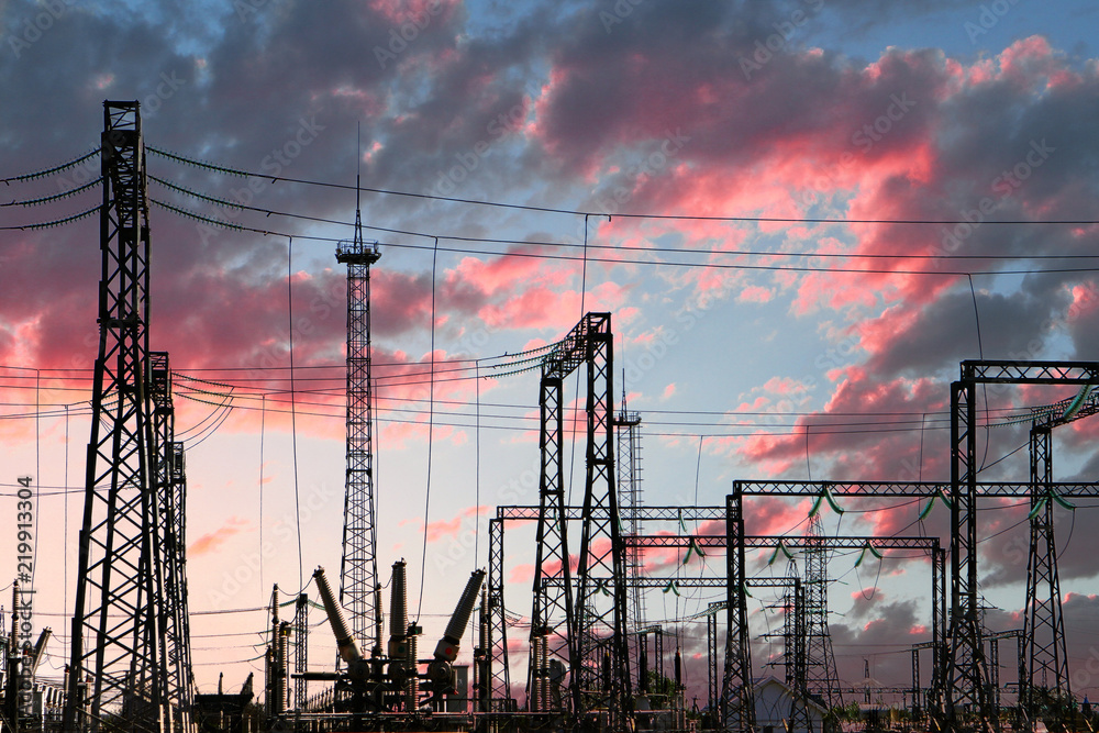 High voltage electric power station - electric poles and lines on red ...