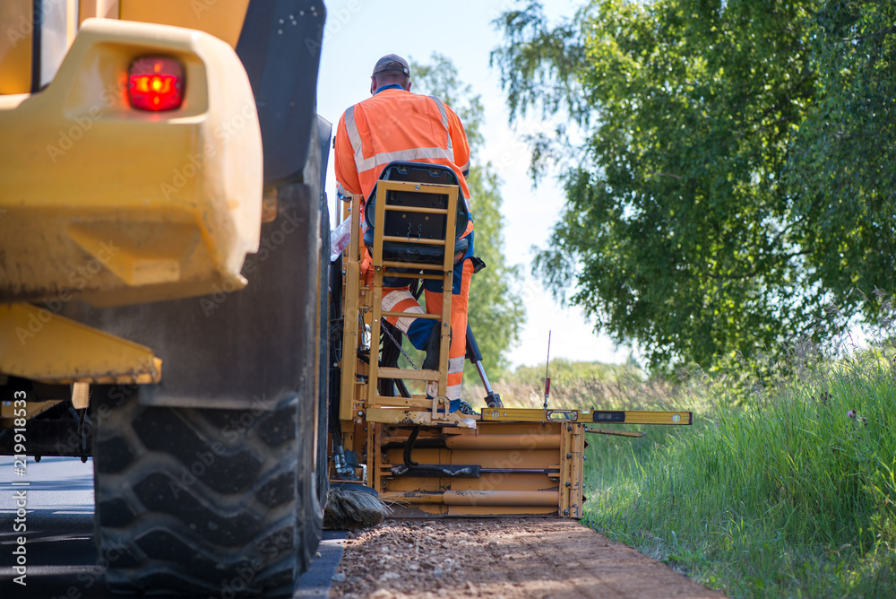 Road construction workers repairing highway road on sunny summer day ...