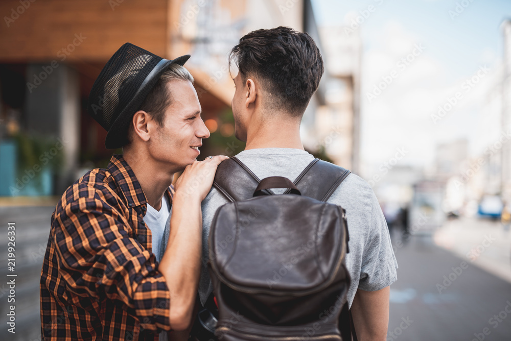 Optimistic male hugging guy while speaking with him. They having fun ...