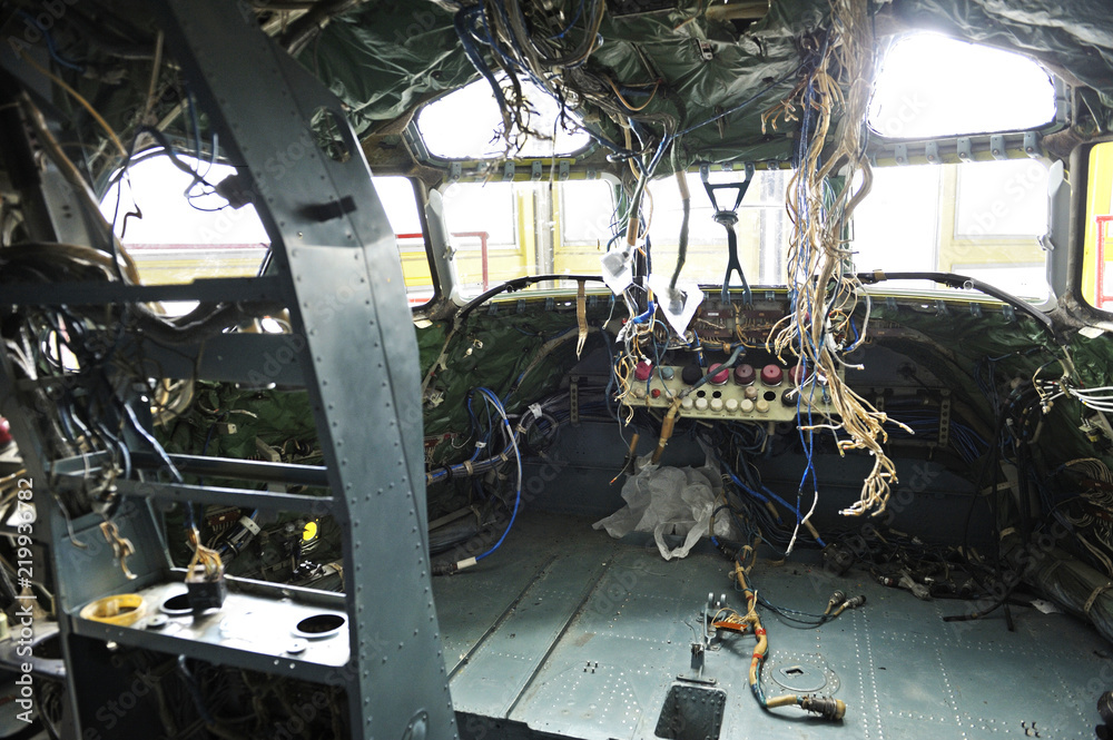 Cockpit of an aircraft in process of repair. Cables hanging down ...