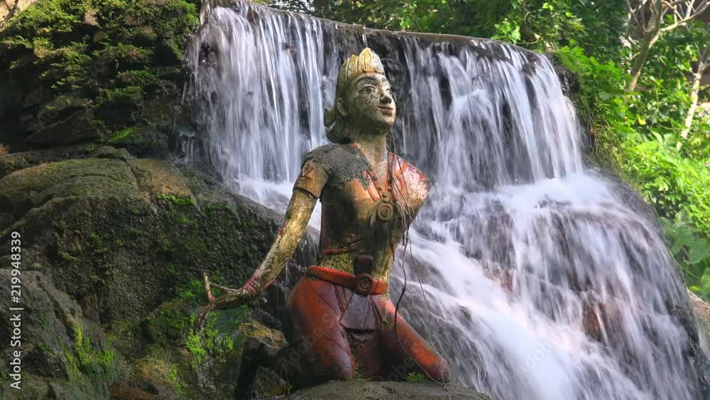 Close-up of statue of mythological creature or deity standing on mossy rock against beautiful ...