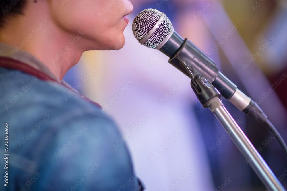 singer and microphone. Close up image of man singing to a microphone ...