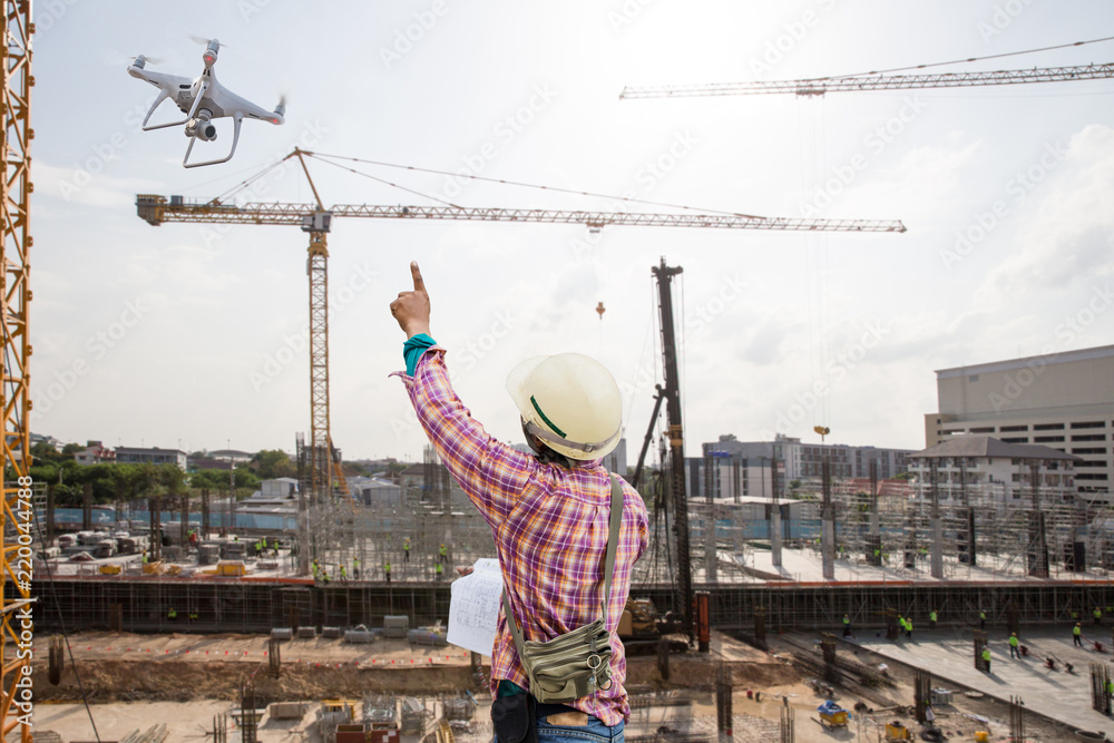 Engineer looking at large building construction site . Drone over ...