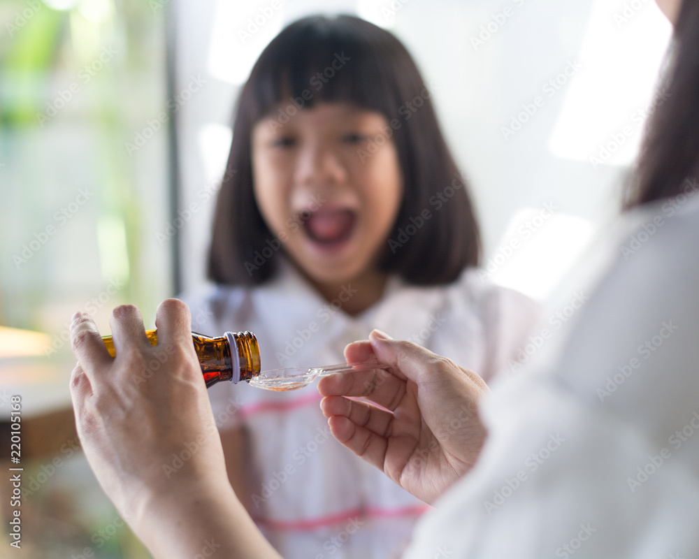 Happy Asia little child girl smiling want to take medicine form mother ...