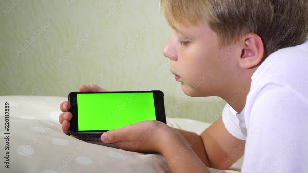 Closeup side view of cute little caucasian kid lying in bed in evening ...