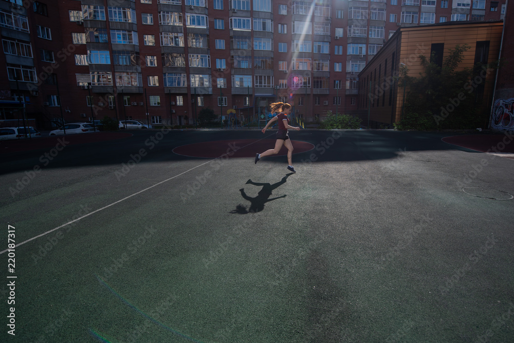 Red-haired young girl runs in the stadium. Student delivers standards ...