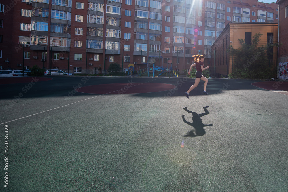 Red-haired young girl runs in the stadium. Student delivers standards ...