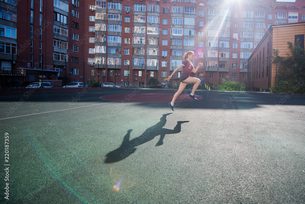 Red-haired young girl runs in the stadium. Student delivers standards ...