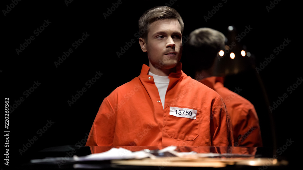 Handcuffed maniac in orange prison jumpsuit looking around in ...