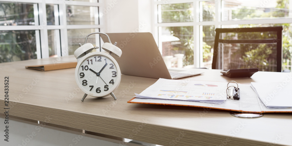 Design of workplace in officer room have a table ,clock,laptop near ...