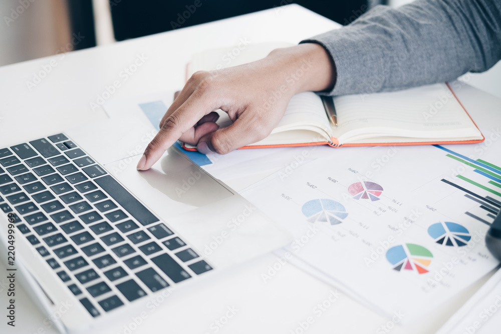 Businessman analyzing investment data charts by using his laptop and ...