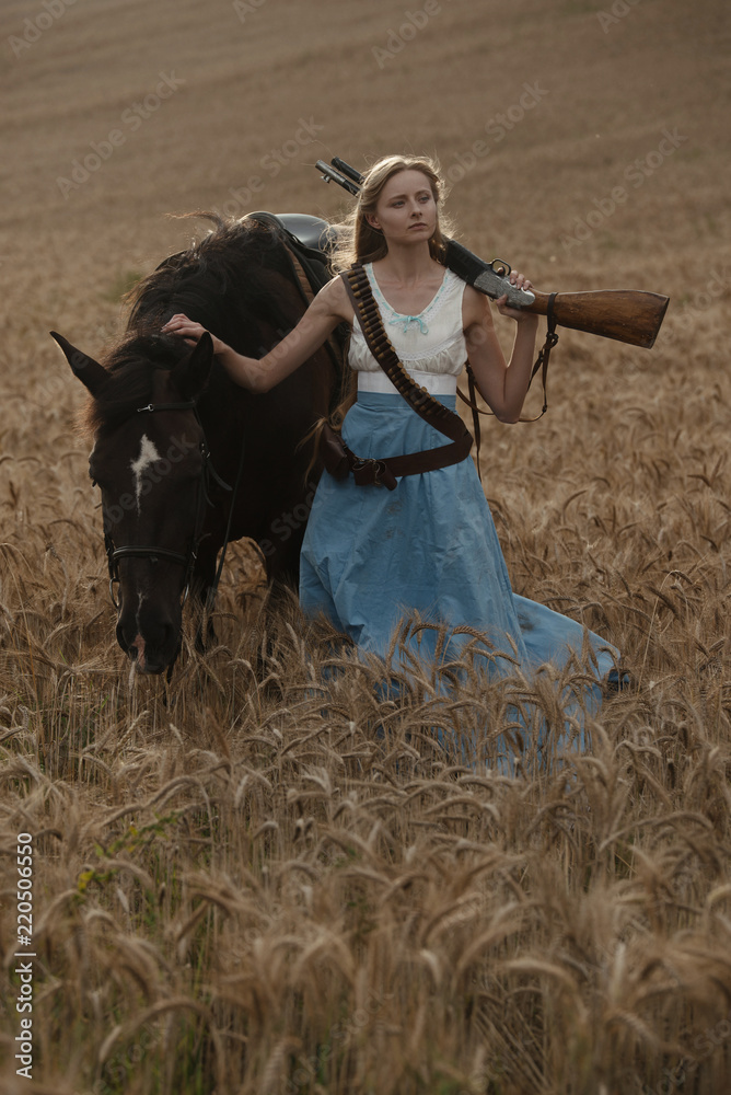 Portrait of a beautiful female cowgirl with shotgun from wild west ...