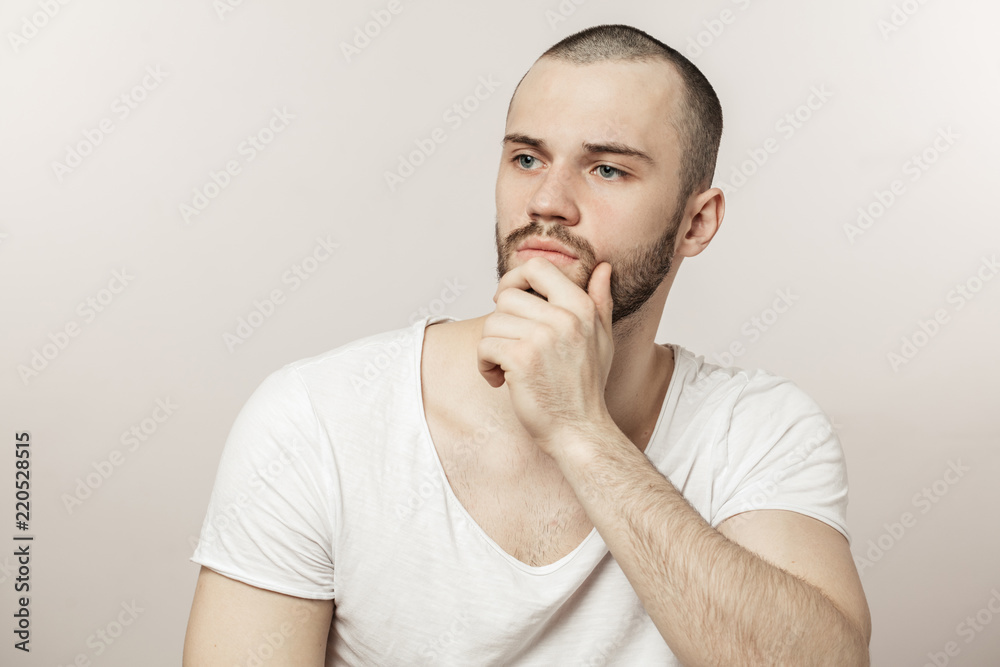 young awesome man making up a plan. pleasant guy touching his chin and ...