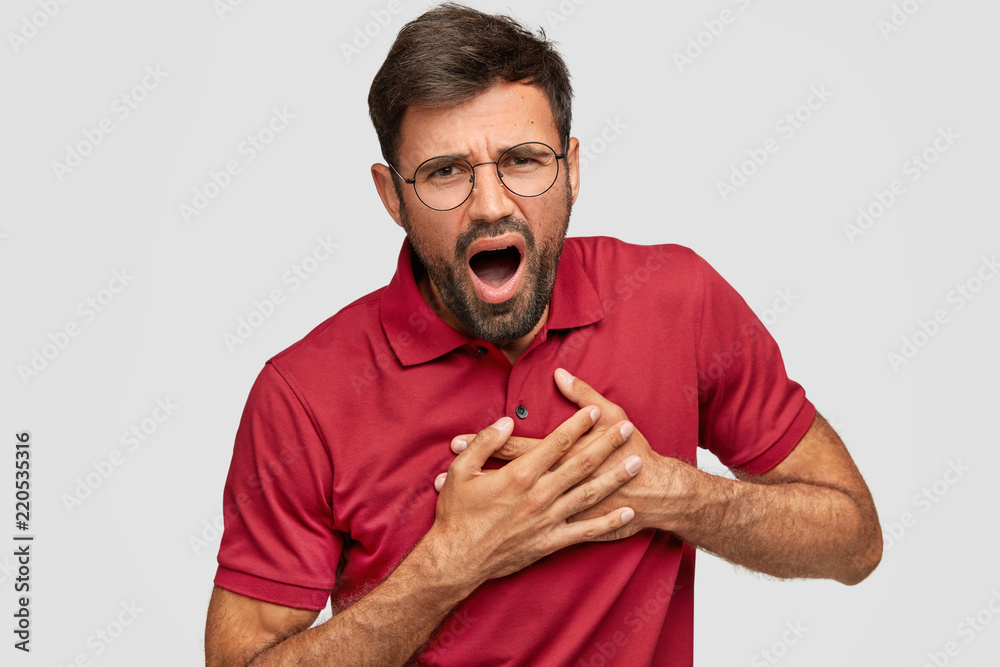 Handsome young man keeps both hands, being stricked by awful news ...