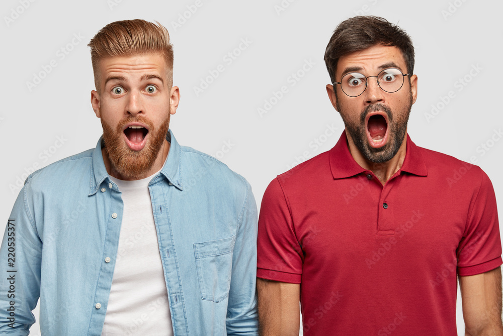 Friendship and emotions concept. Stunned emotive two men keep jaw ...