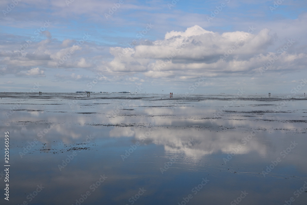 Nordsee bei Ebbe vor Cuxhaven mit Spiegelung der Wolken bei ablaufenden ...