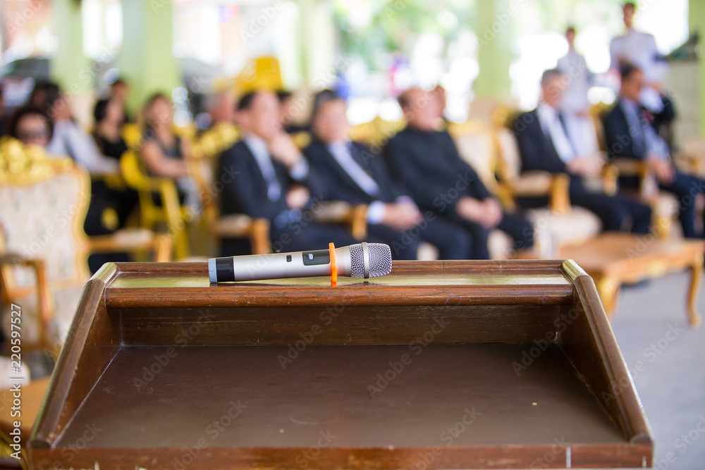 microphone placed on the podium in conference room with blur people ...