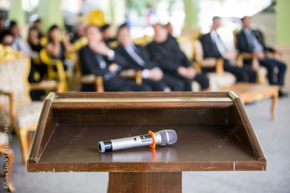 microphone placed on the podium in conference room with blur people ...