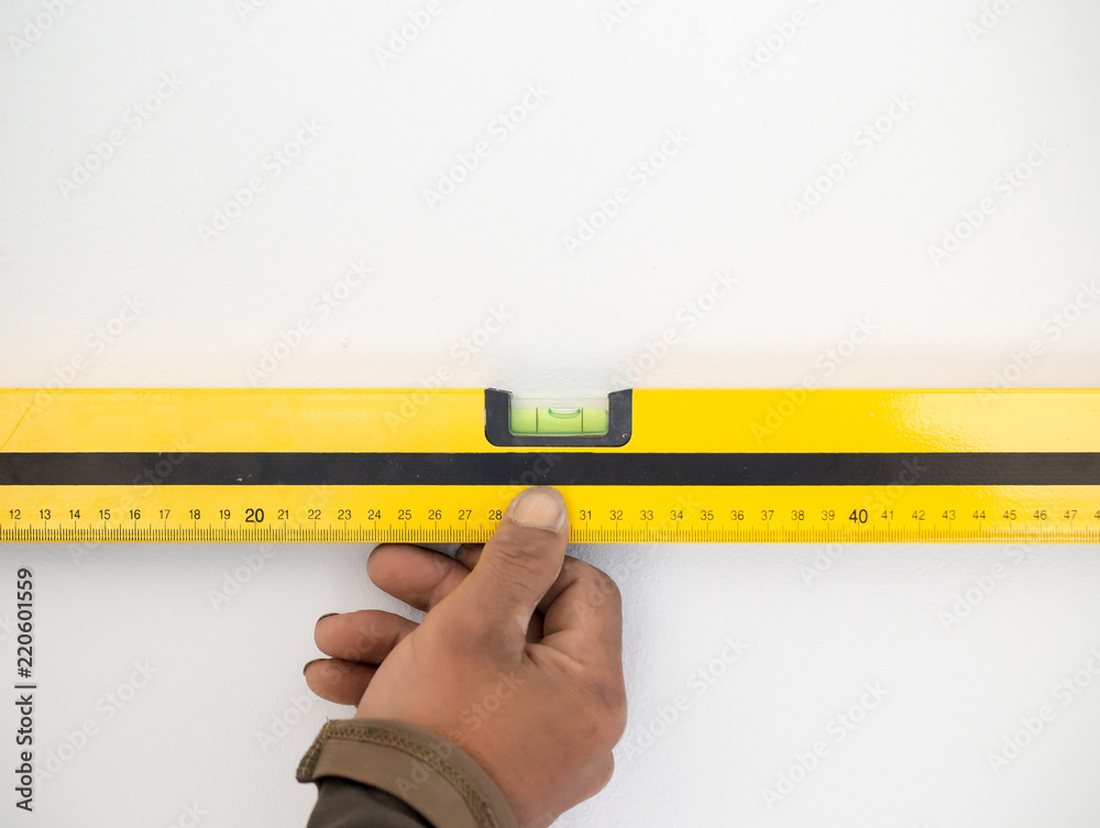 Industrial worker use building level to check balance edge of wall to ...