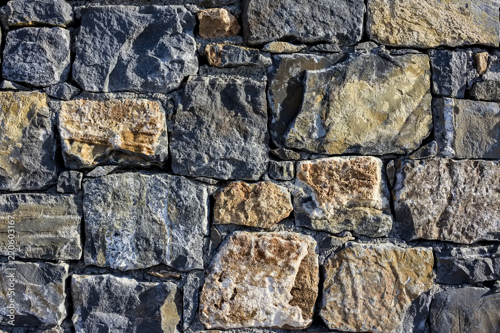 large wall of natural granite stones of different size and color, gray ...