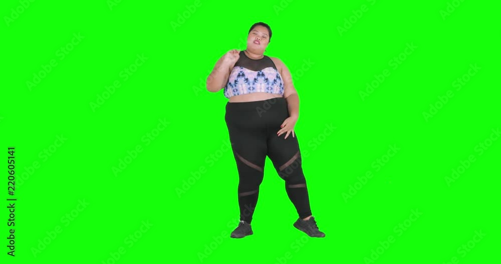 Overweight young woman dancing in the studio while wearing sportswear ...