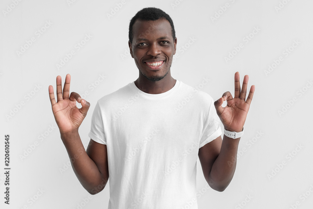 Young black man having happy look, smiling, gesturing, showing OK sign ...